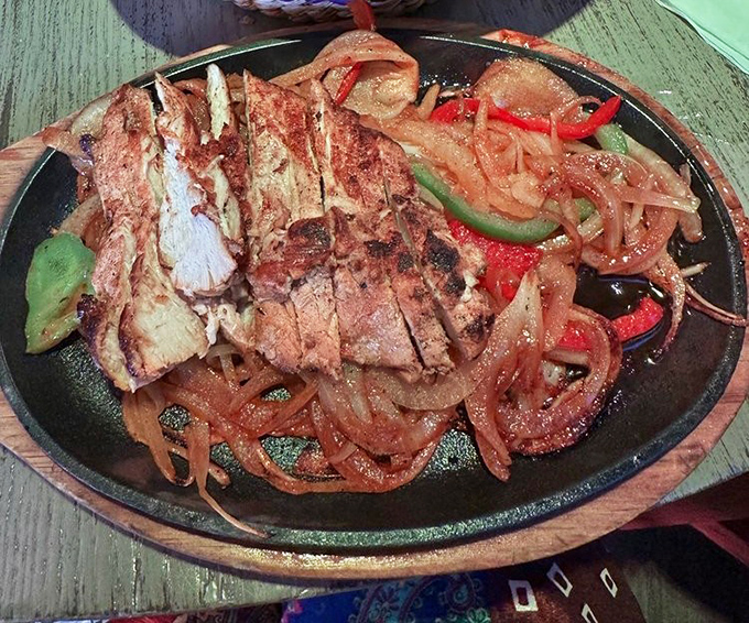 Sizzling fajitas arrive with theatrical flair, a symphony of sound and steam that turns every head in the restaurant.