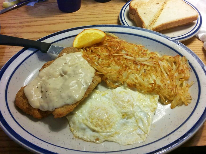 The chicken fried steak arrives like edible armor, draped in country gravy with golden hash browns standing guard – a breakfast of champions.