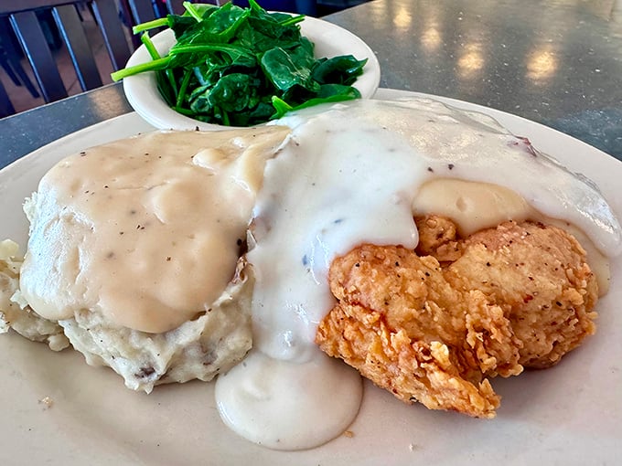 The holy trinity of Southern comfort: crispy chicken fried steak, creamy mashed potatoes, and peppery gravy&mdash;with a side of greens to pretend you're being healthy.