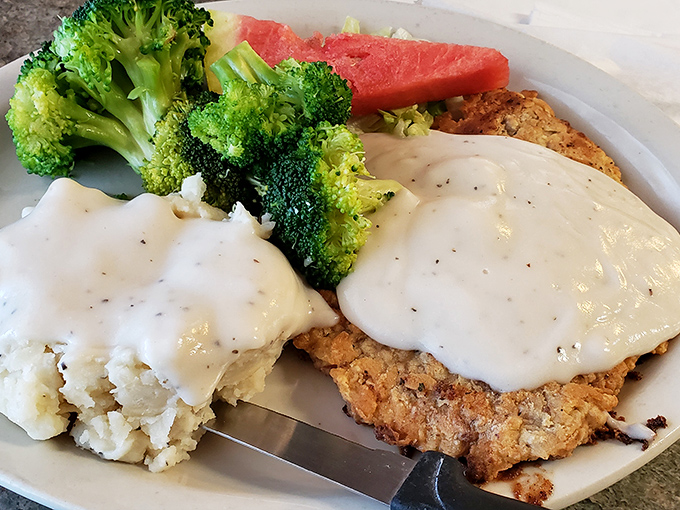 Country-fried perfection smothered in peppery gravy alongside fluffy mashed potatoes. This plate doesn't just feed your body – it soothes your soul.