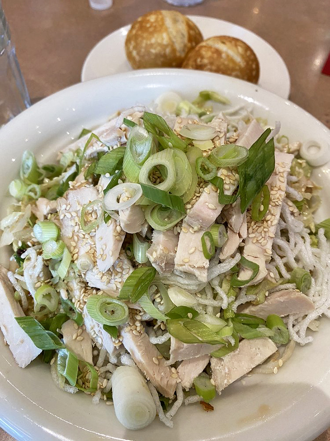 This isn't just chicken salad &ndash; it's a textural symphony of tender meat, crisp scallions, and sesame seeds that Mozart would have composed for.