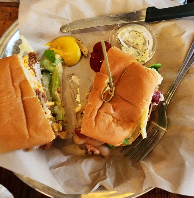 A burger cut in half reveals the architectural perfection within&mdash;layers of flavor stacked with the precision of a culinary engineer.