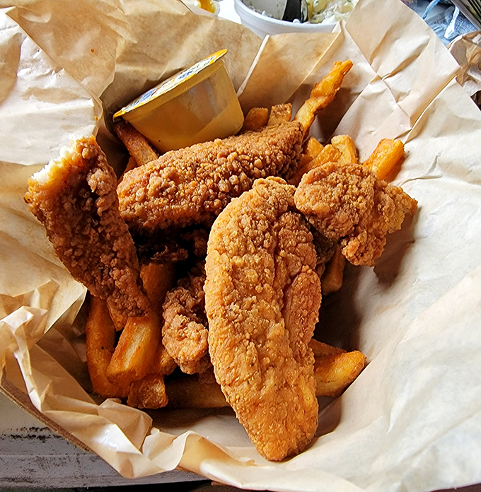 Golden-fried chicken tenders that could make a vegetarian question their life choices, nestled alongside fries that somehow maintain their crispness even under the cave's natural humidity.