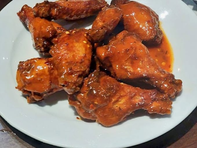 Buffalo wings that don't mess around. That glossy sauce promises the perfect balance of heat and tang&mdash;napkins required, regrets impossible.