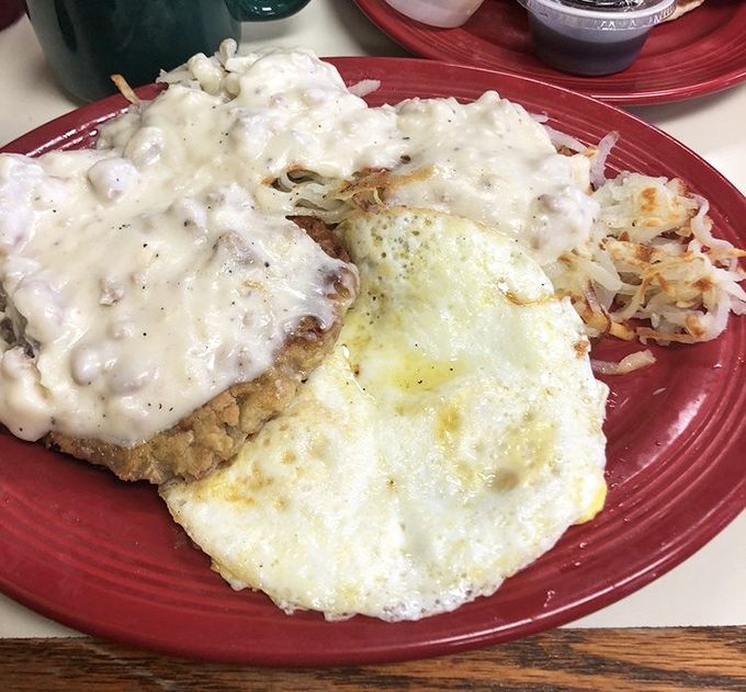 Country fried steak smothered in creamy gravy alongside sunny-side-up eggs and crispy hash browns&mdash;the breakfast trifecta that makes morning people out of night owls.
