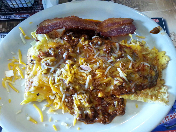 Hash browns loaded with cheese and chili alongside bacon&mdash;because subtle was never really Texas's thing, and we're grateful for it.