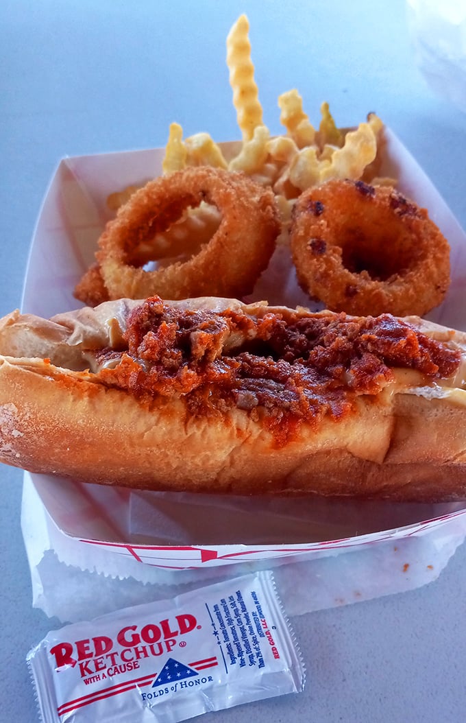 The chili dog arrives with crispy companions&mdash;golden onion rings and fries that make you wonder why you ever bothered with fancy restaurants.
