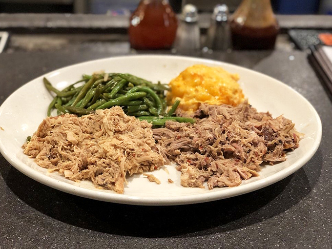 Pulled pork piled high enough to require structural engineering, accompanied by green beans that actually taste like vegetables should.