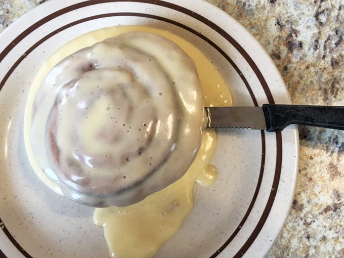Behold the cinnamon roll in its natural habitat&mdash;swimming in a pool of icing, waiting to fulfill its destiny as your morning's sweetest mistake.