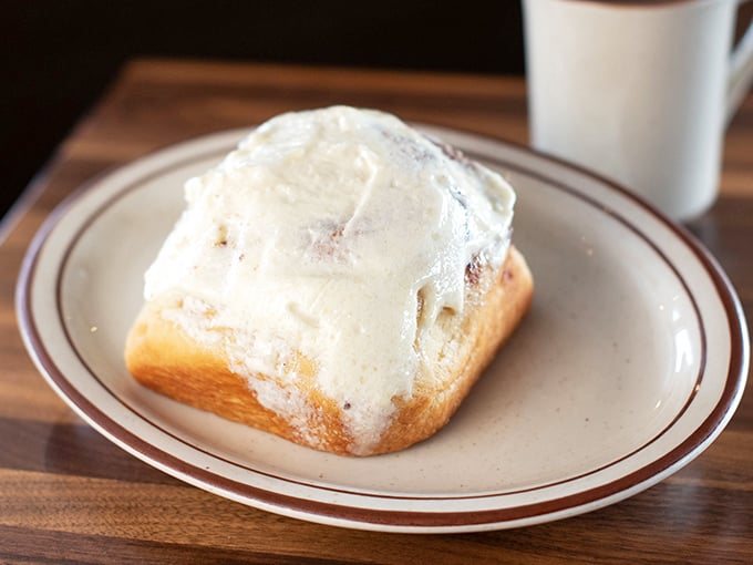The cinnamon roll doesn't just arrive at your table&mdash;it makes an entrance, wearing its frosting like a decadent winter coat that's melting in all the right places.