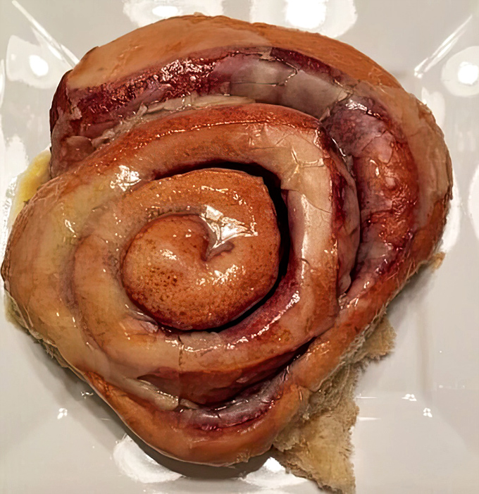 This cinnamon roll isn't just breakfast, it's an architectural marvel of swirled dough and glistening glaze that demands respect.