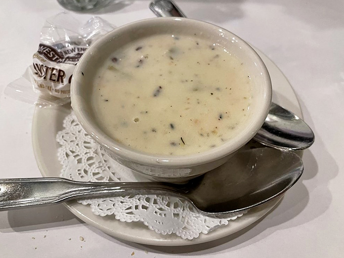 Clam chowder that achieves the perfect balance between creamy and briny. Served on a doily because even comfort food deserves a proper presentation.