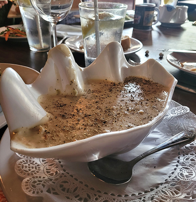 The clam chowder arrives in a sculptural shell bowl, like Neptune himself designed the perfect vessel for this creamy ocean treasure.
