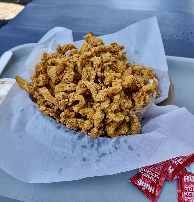 Whole belly clam strips glistening with golden perfection, proving that sometimes the best things in life are battered, fried, and absolutely irresistible.