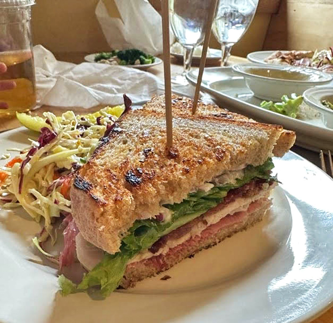 Behold the club sandwich in its natural habitat&mdash;stacked tall enough to require strategic first-bite planning, with slaw that isn't an afterthought.