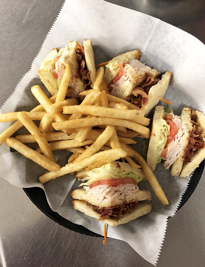 A club sandwich that doesn't mess around&mdash;stacked high with layers of goodness and accompanied by golden fries that could make a potato farmer weep with pride.