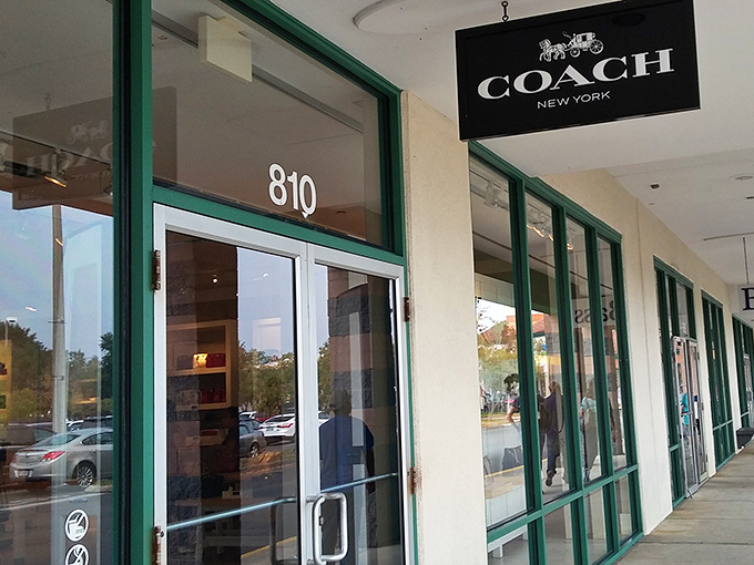 The Coach store entrance stands like a leather-scented portal to a world where handbags aren't just accessories but personality statements.