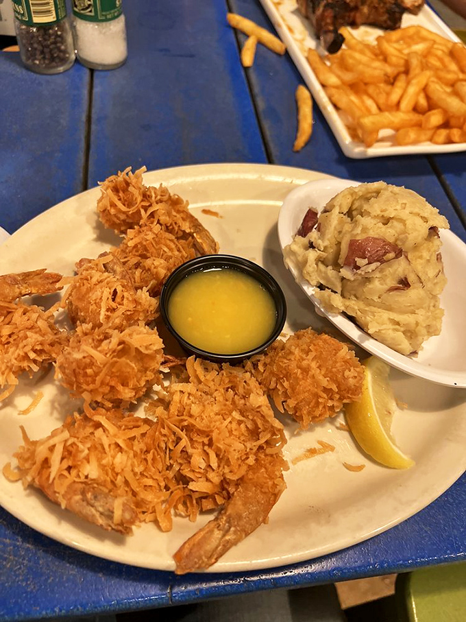 Golden-fried coconut shrimp that crunch like a satisfying beach day, served with smashed potatoes that might make you forget about French fries altogether.