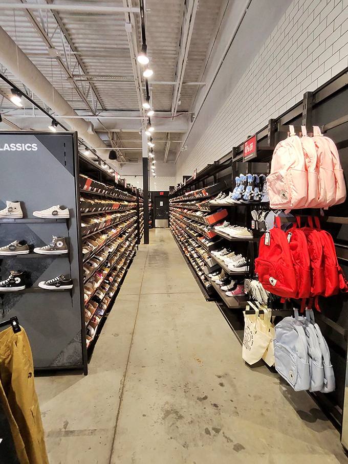The Converse store's sneaker wall stretches into infinity, a cathedral of casual footwear where Chuck Taylor disciples find their soles.
