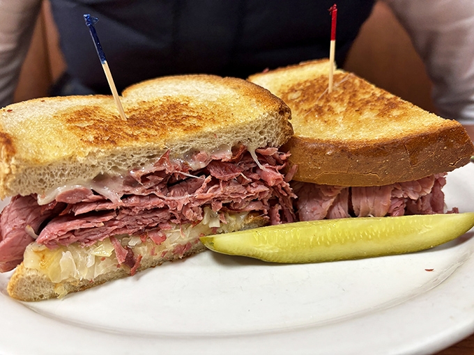 This Reuben isn't messing around. Corned beef stacked higher than my college debt, with sauerkraut providing that perfect tang. The pickle stands guard, knowing its supporting role.
