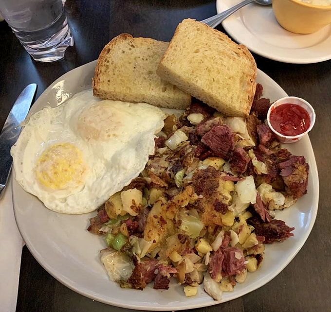 This isn't just corned beef hash; it's a masterclass in breakfast architecture with crispy edges, tender potatoes, and that perfect sunny-side egg.