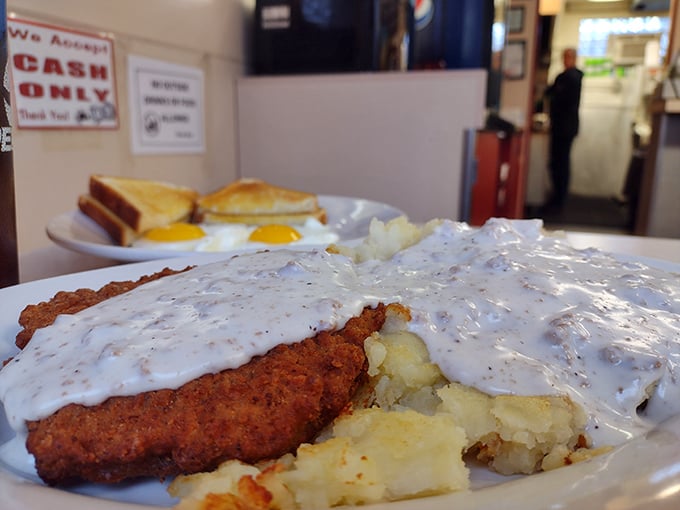 Country fried steak swimming in peppery gravy alongside golden potatoes – the kind of breakfast that fuels both body and soul.