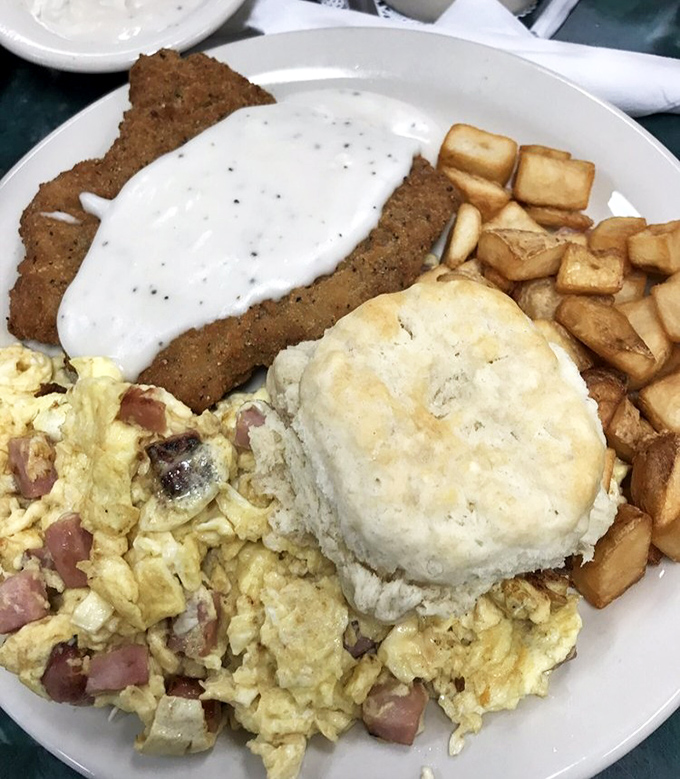 Breakfast nirvana achieved: country fried steak, scrambled eggs studded with ham, home fries, and a biscuit that could make a grown person weep with joy.