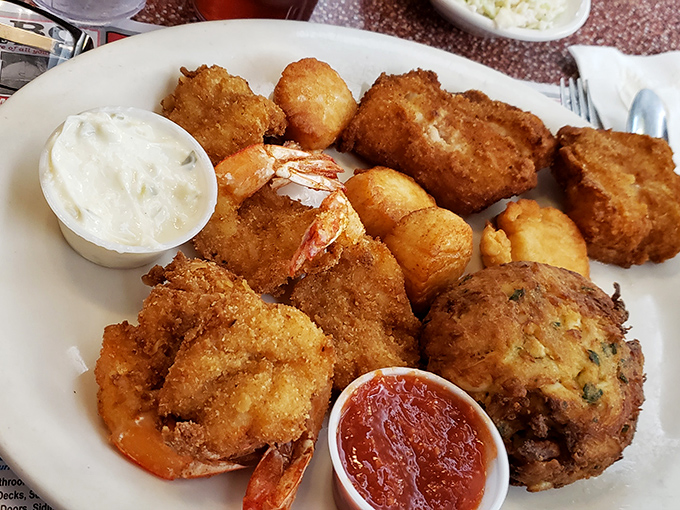 The seafood platter arrives like a crispy golden treasure chest from the Chesapeake, with crab cakes that actually taste like crab, not breadcrumbs with aspirations.
