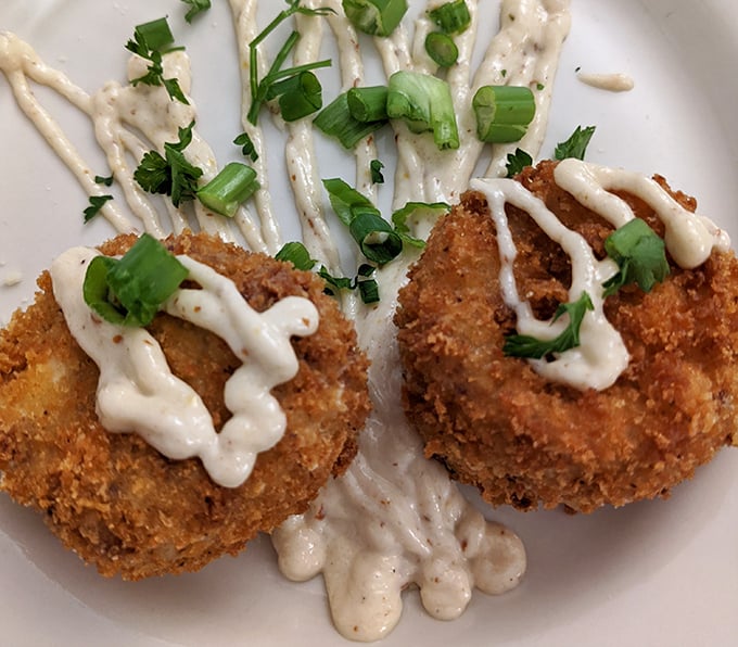 These golden-fried crab cakes with their delicate remoulade drizzle might just make you consider a permanent move to the Big Easy.