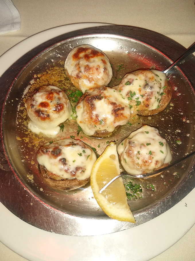 These stuffed mushrooms arrive bubbling like tiny edible volcanoes, each one a perfect bite of decadent seafood luxury.