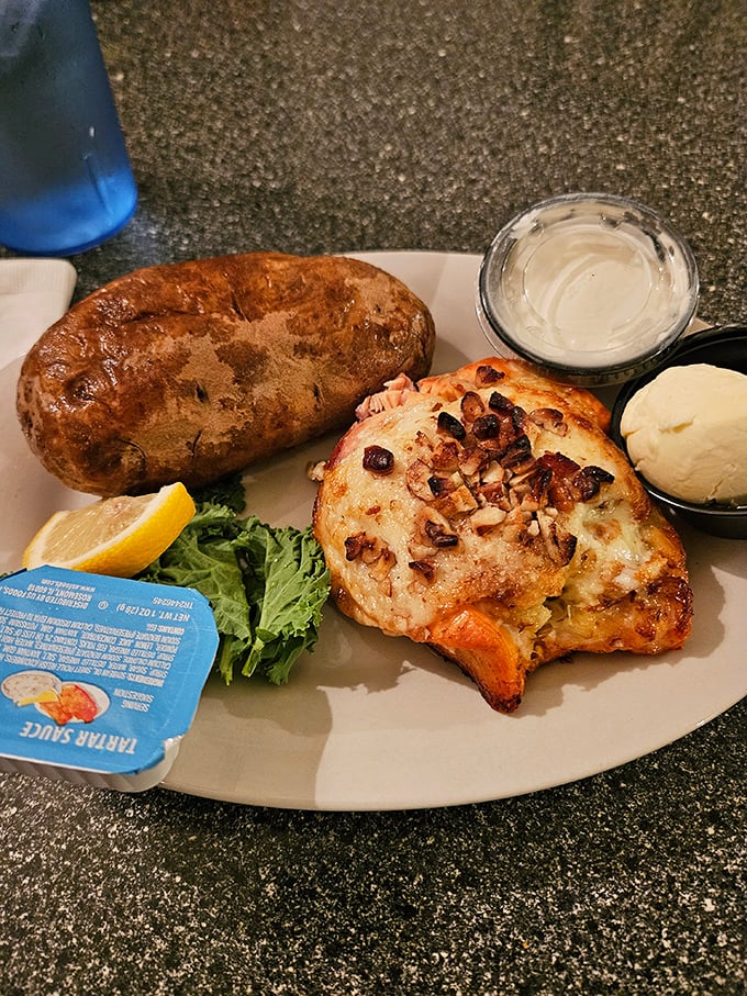 The crab-stuffed fish with a golden-brown crust sits beside a baked potato that could feed a small village. Comfort food elevated to an art form.