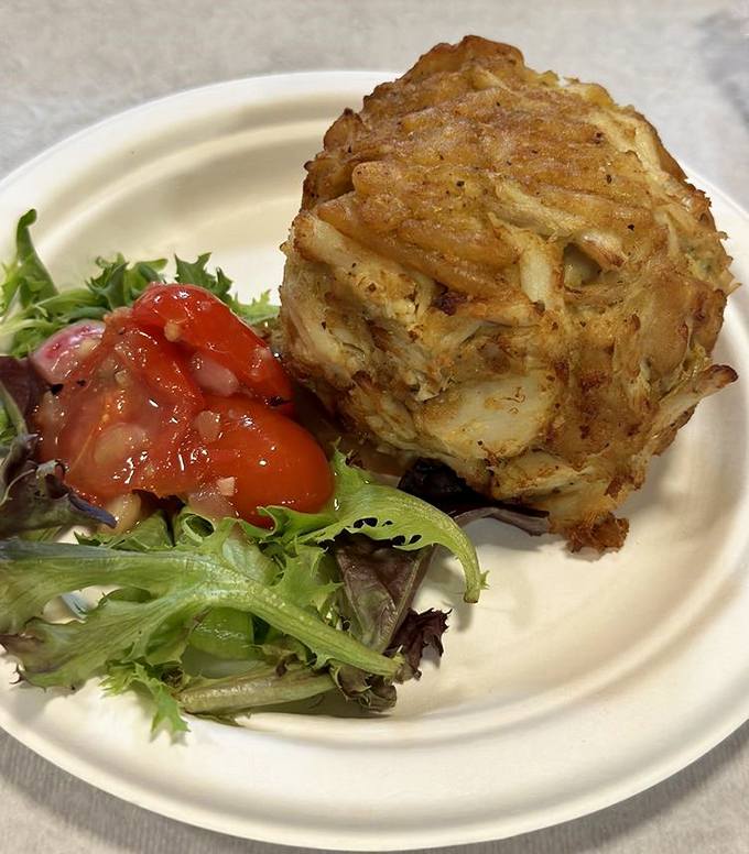 The jumbo lump crab cake sits like royalty, demanding respect and delivering pure Maryland magic.