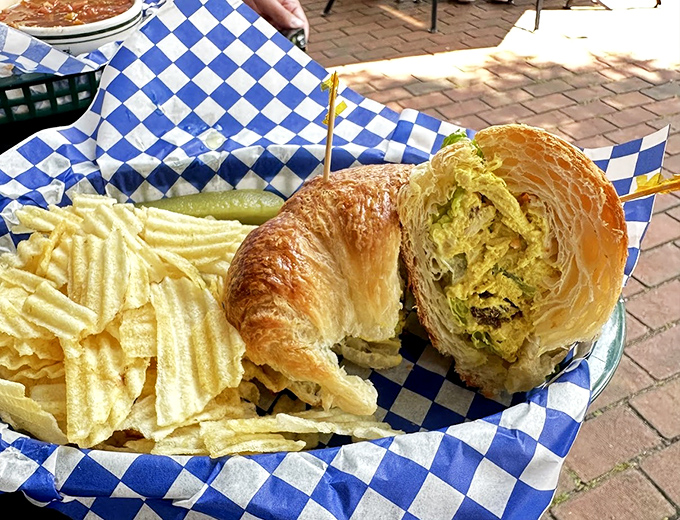 A croissant sandwich that's achieved the impossible trifecta: flaky exterior, substantial filling, and the ability to make potato chips seem like a necessary sidekick.