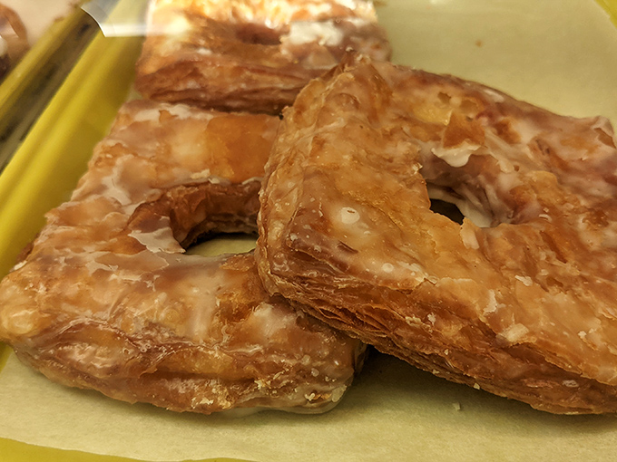 Croissant donuts stacked like golden treasure, their flaky layers promising a textural adventure that makes choosing just one practically impossible.