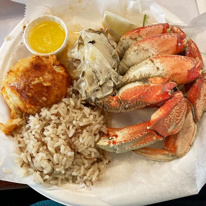 Dungeness crab meets perfectly cooked rice and a golden crab cake—a holy trinity of seafood satisfaction that makes plastic utensils feel like fine silver.