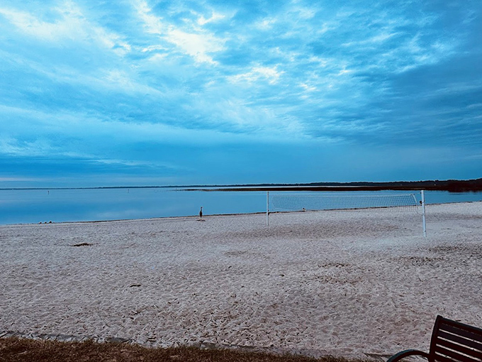 Volleyball nets await the next friendly match as twilight paints East Lake Toho in shades of blue. Beach games just hit different when there's no salt in your eyes.