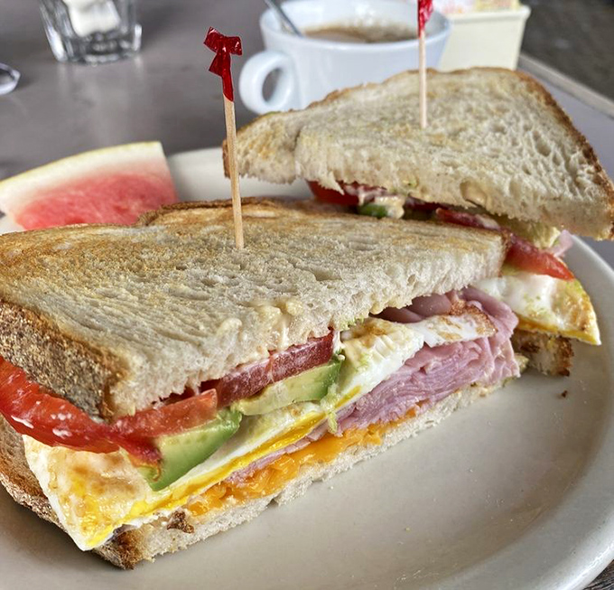 Sandwich architecture at its finest &ndash; layers of egg, ham, and fresh vegetables stacked with the precision of a Jenga master who's also a flavor scientist.