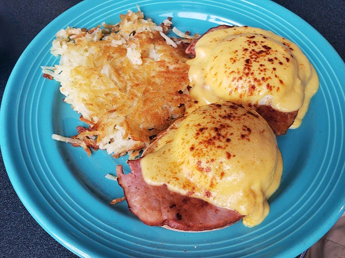 Eggs Benedict: where hollandaise dreams come true. That perfect golden yolk is about to make those hash browns even happier.