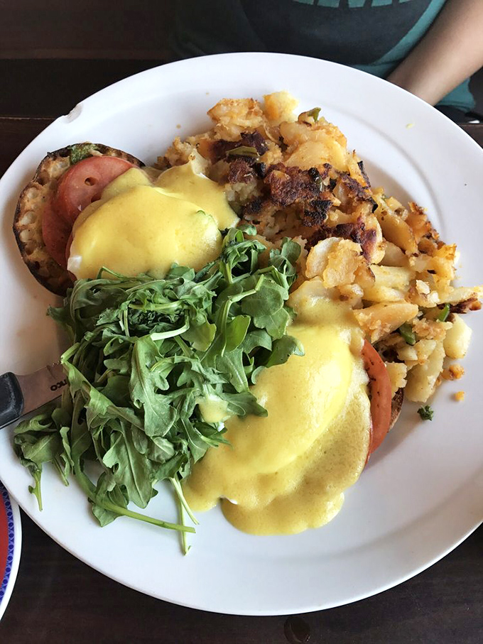 Eggs Benedict reimagined with crispy potatoes and fresh arugula – proof that classics can learn new tricks without losing their soul.