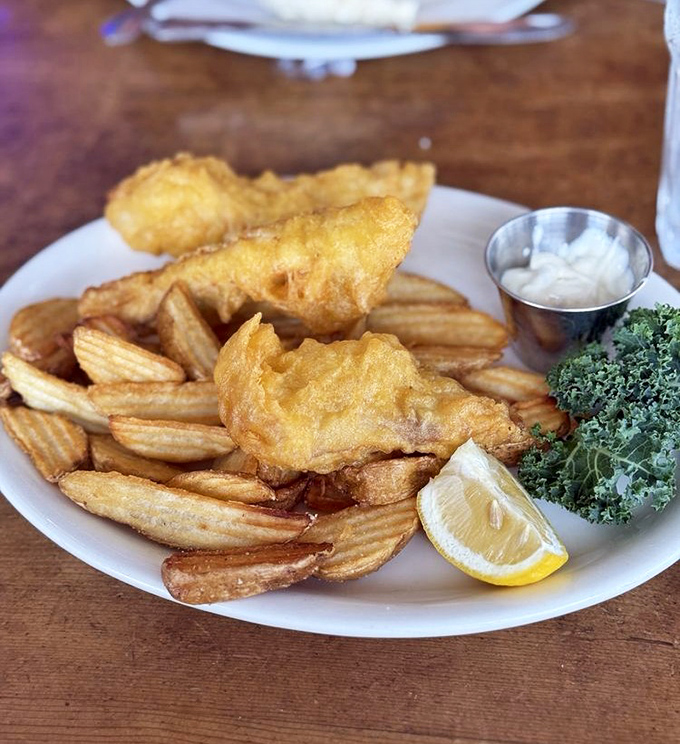 Fish and chips that would make a British pub jealous. The golden batter shatters just right, while that lemon wedge stands by, ready for its supporting role.