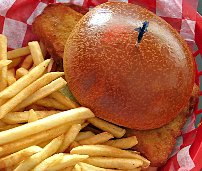 The golden-brown bun crowns this fish sandwich like a royal hat, while the crispy fillet holds court over perfectly golden fries.