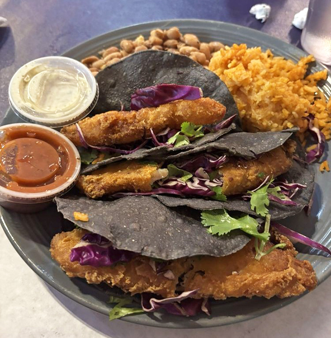 These fish tacos aren't just a meal, they're an edible art installation with crispy fish, purple cabbage, and cilantro on dramatic blue corn tortillas.