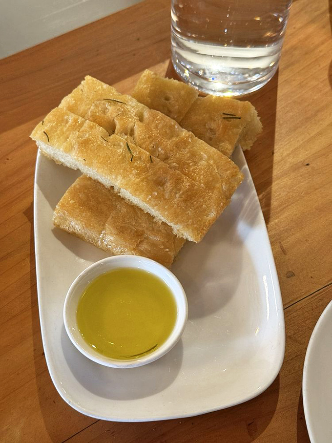 Focaccia and olive oil: the original power couple. Simple, golden, and ready to kickstart your meal with carb-loaded joy.