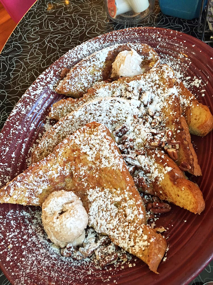 French toast that makes regular toast look like it's not even trying, dusted with powdered sugar and topped with whipped cream islands.
