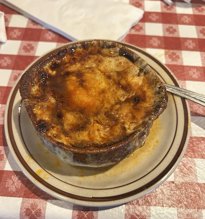 The French onion soup arrives like a bubbling cauldron of comfort, its cheese cap stretching skyward with each spoonful &ndash; a perfect prelude to steak.