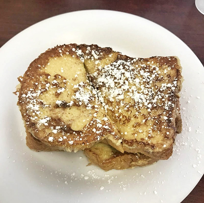 French toast that's achieved the impossible trifecta: crispy edges, custardy center, and just enough powdered sugar to make you feel like you're getting away with something.