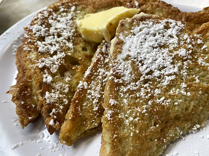 French toast that's dressed for success with a dusting of powdered sugar and a generous pat of butter melting into every nook and cranny.