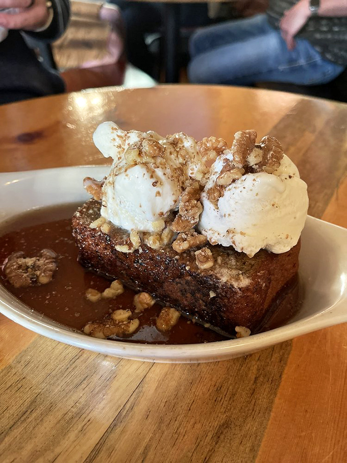 Dessert that makes you close your eyes and forget your manners—warm banana bread crowned with ice cream and walnuts in caramel's embrace.