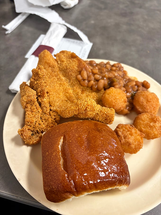 This isn't just a meal; it's a Southern trinity. Crispy catfish, baked beans with that perfect sweet-savory balance, and a roll that could make a carb-counter weep.