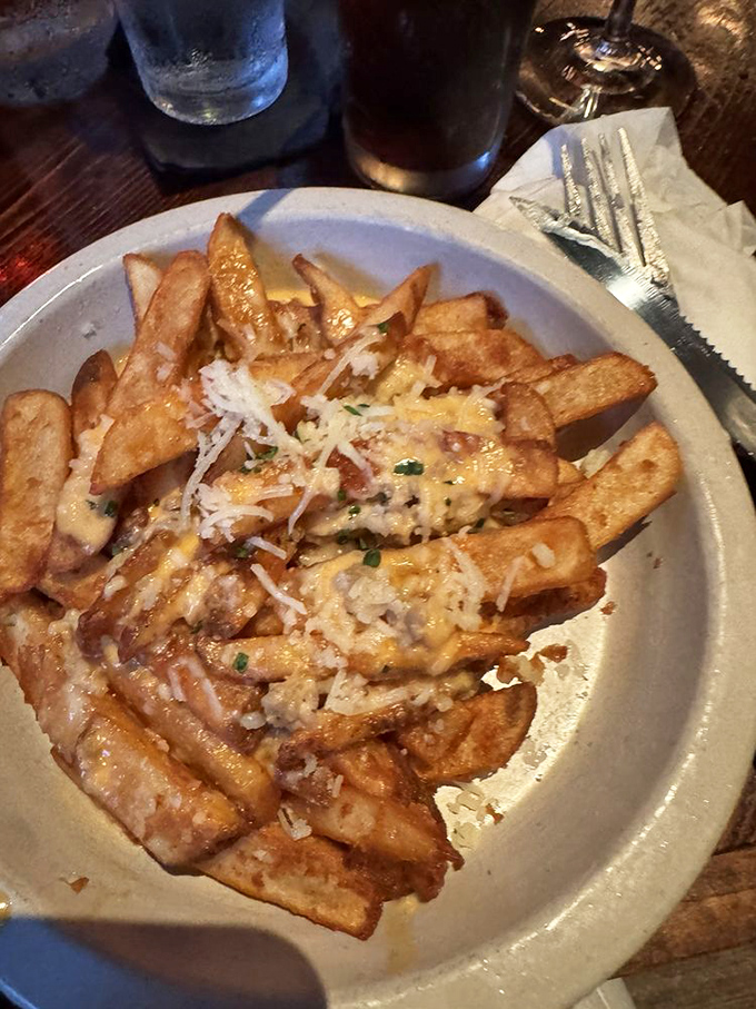 These aren't just fries – they're golden pillars of potato perfection, crowned with cheese and herbs that make ketchup entirely unnecessary.